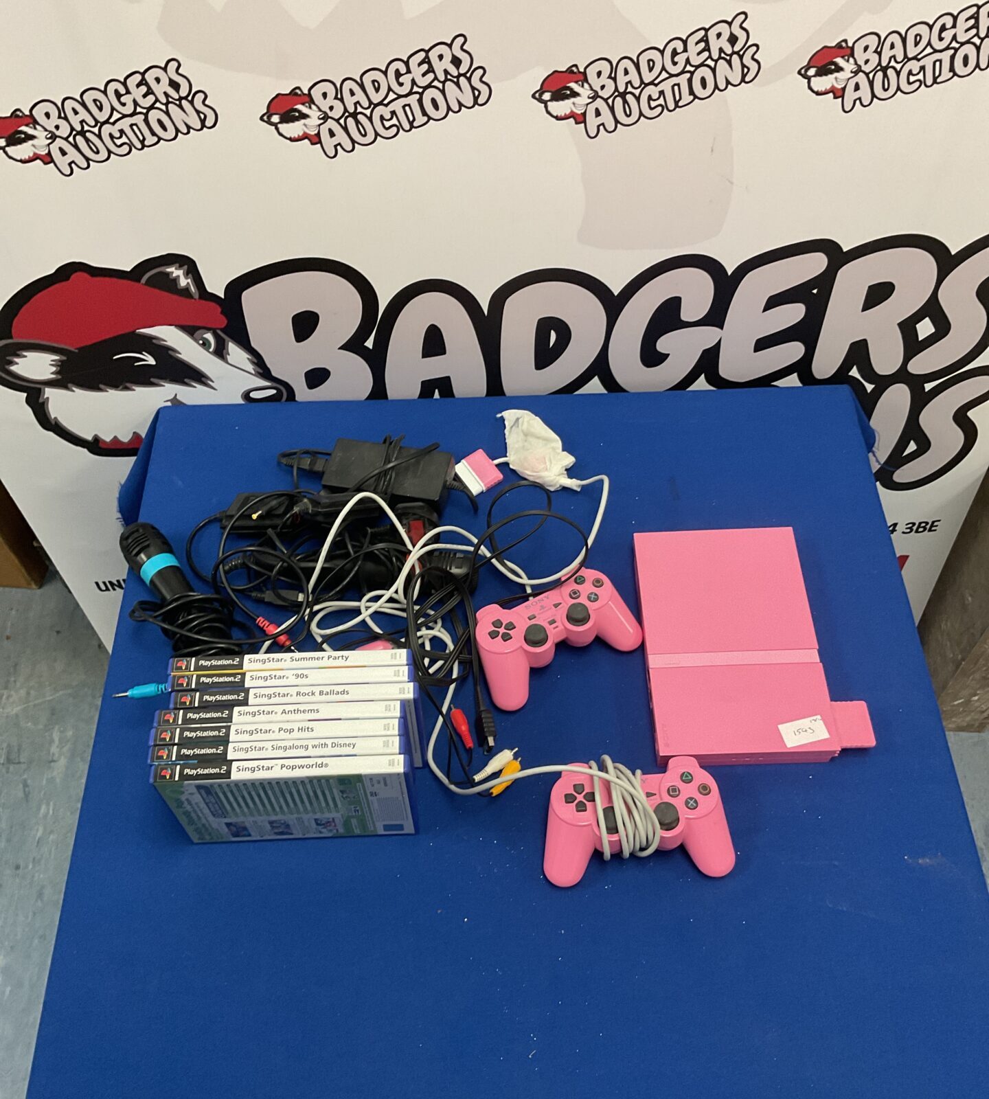 Pink Playstation 2 console with two remotes and selection of SingStar ...